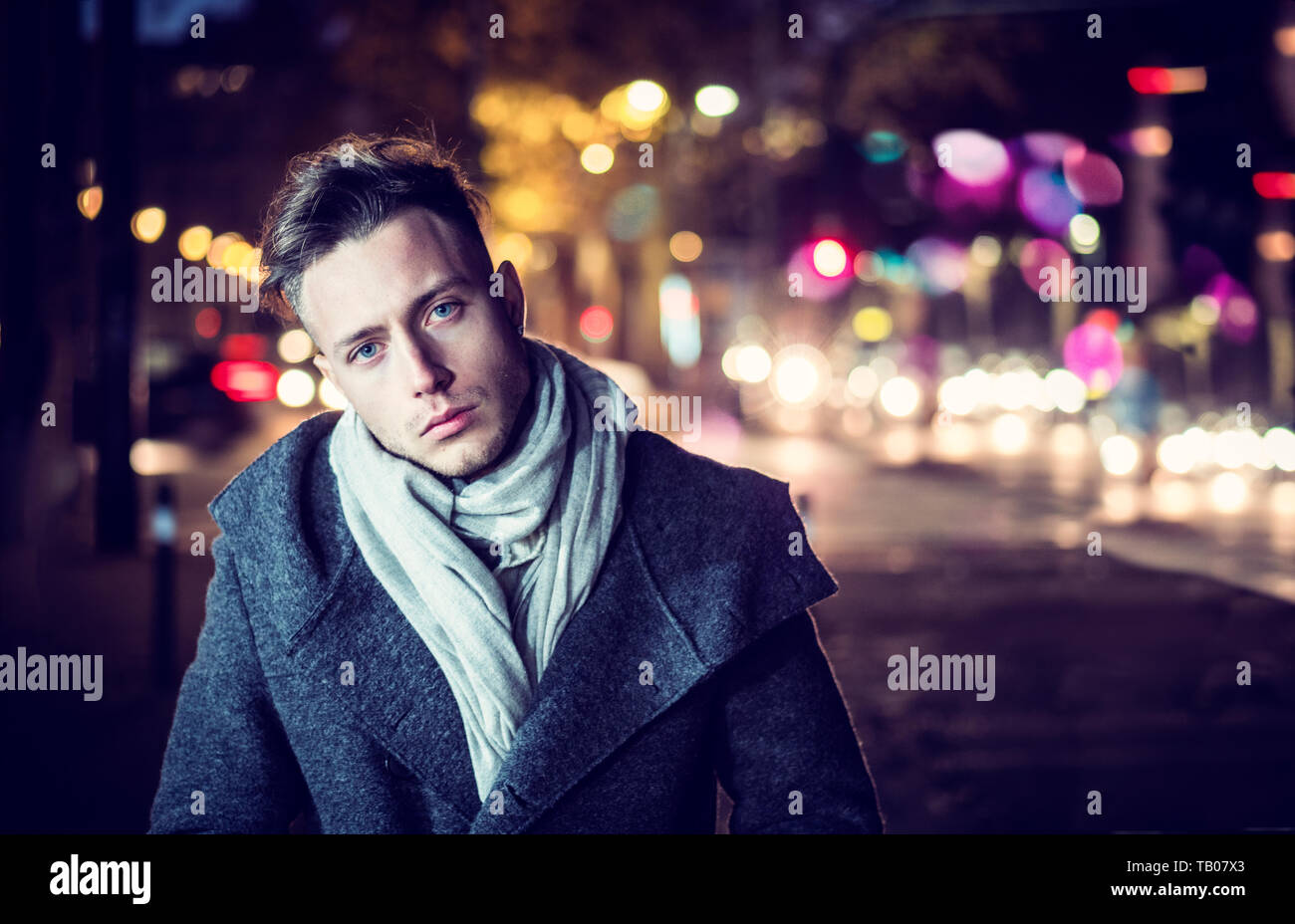 Handsome trendy young man, standing on a sidewalk at night Stock Photo ...