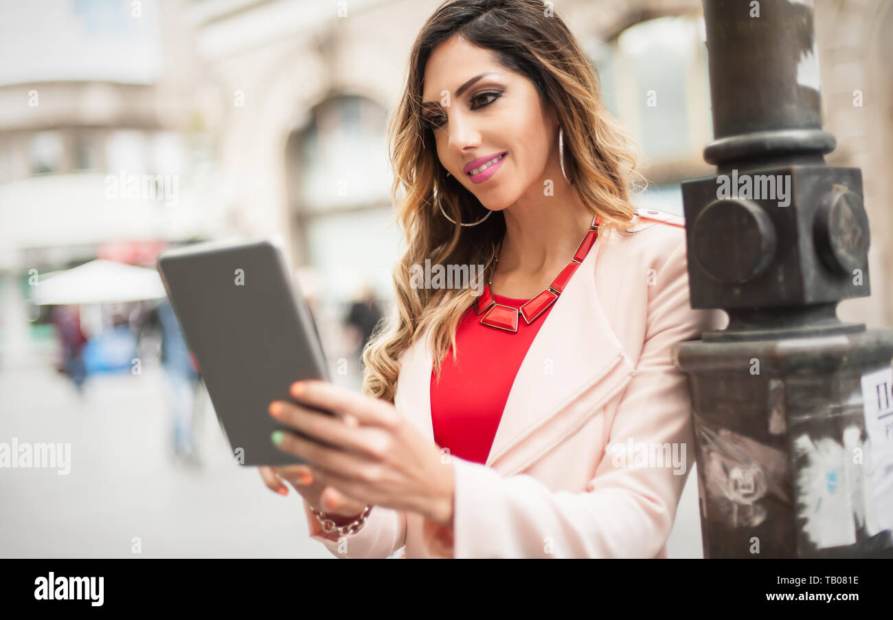 Young woman using digital tablet computer, surfing internet, city ...