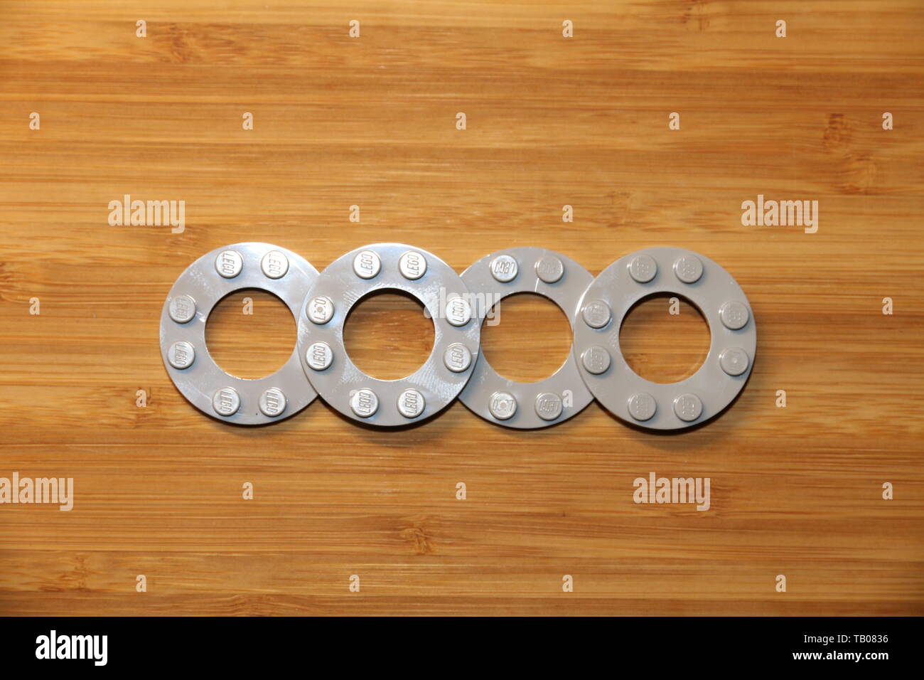 LEGO Audi emblem from light bluish gray plate rings on a wood table ...