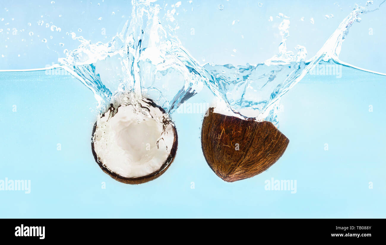 Cracked coconut with splashes falling in water Stock Photo - Alamy