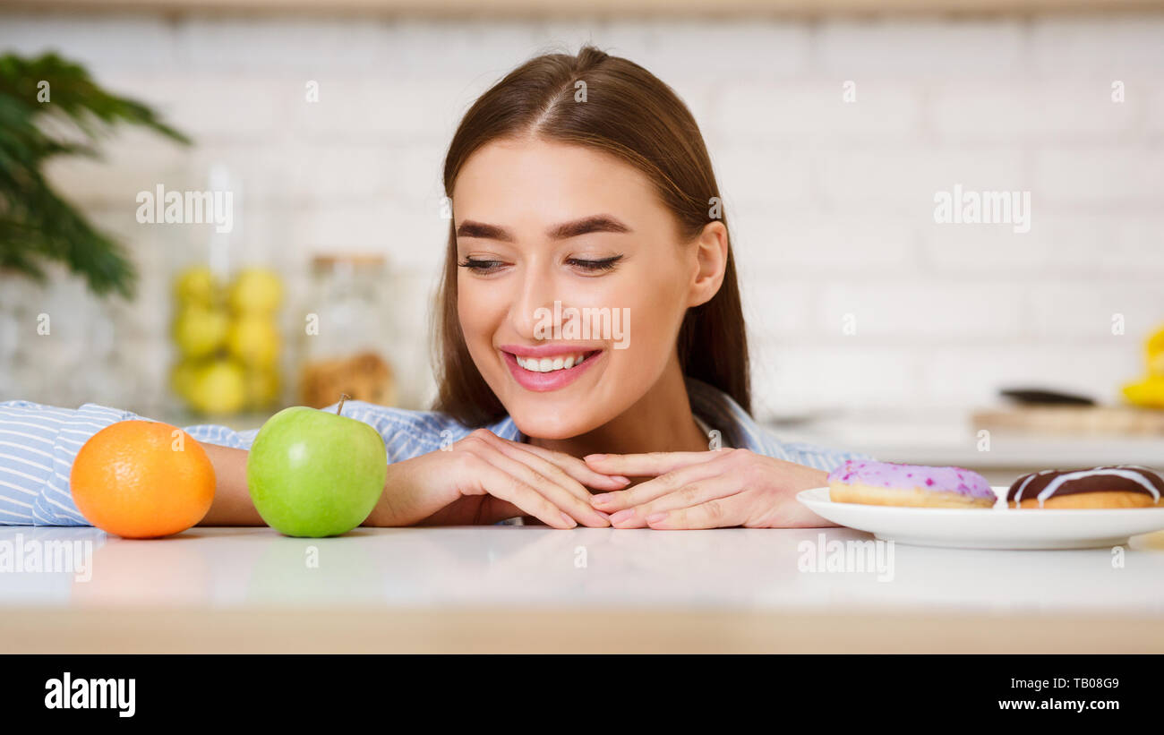 Healthy Food. Woman Choosing Between Fruits And Sweets Stock Photo - Alamy