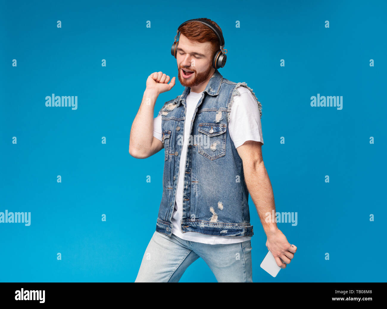 Redhaired man enjoying music and dancing on background Stock Photo - Alamy