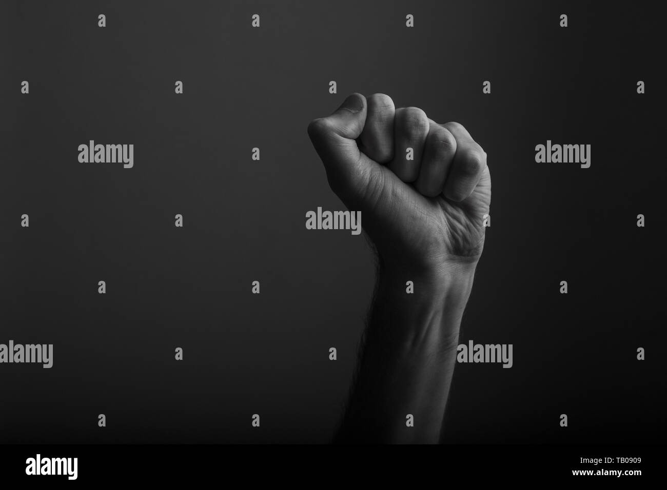 Raised clenched fist against a dark background, power, protest concept ...