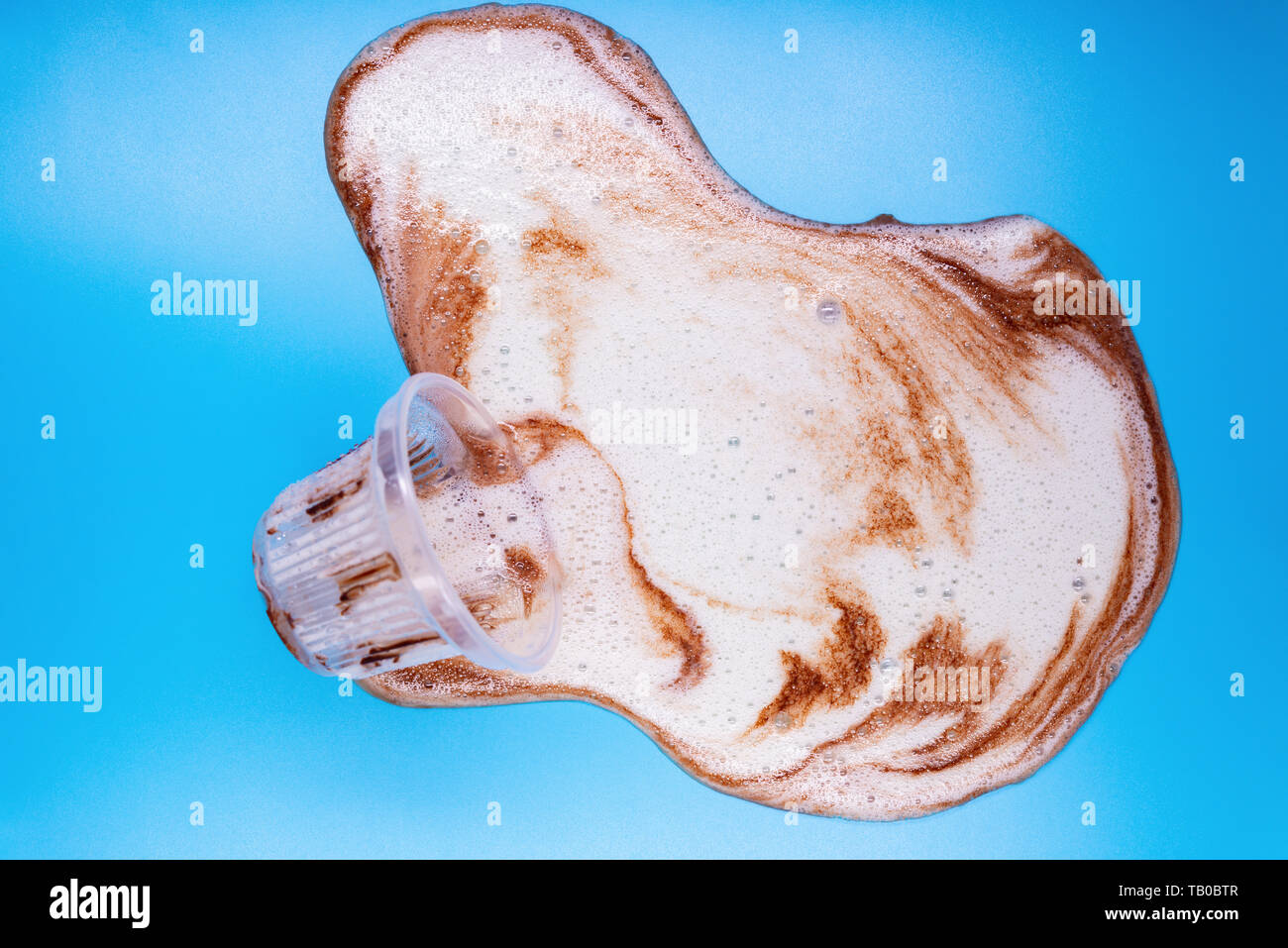 top view cup of chocolate flavor ice cream melting on blue background ...