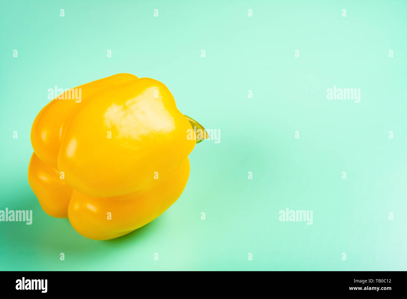 fresh yellow bell pepper on a light green background with copy space ...