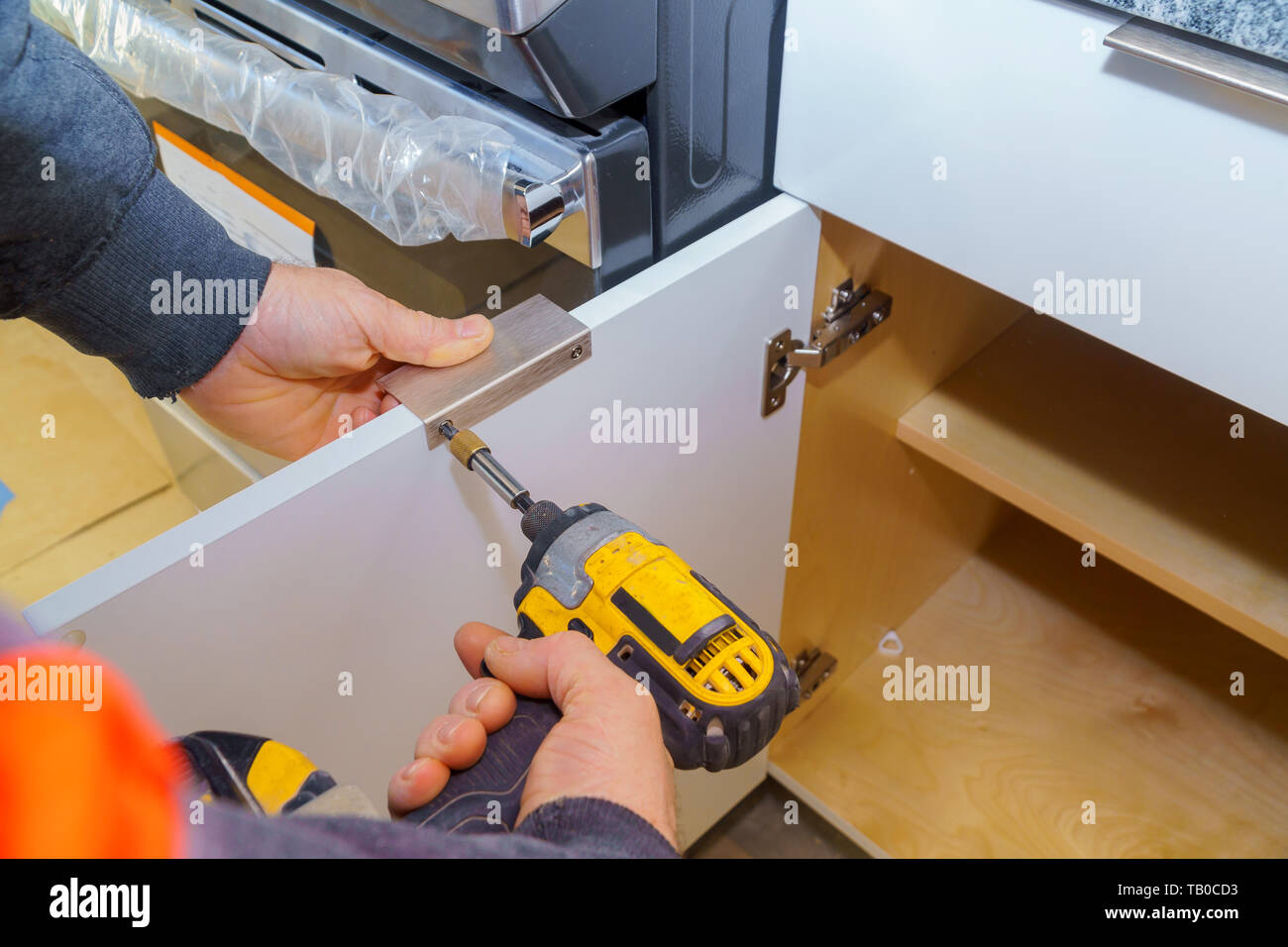 Hand on handle installation of door handles on opening cabinet door in ...