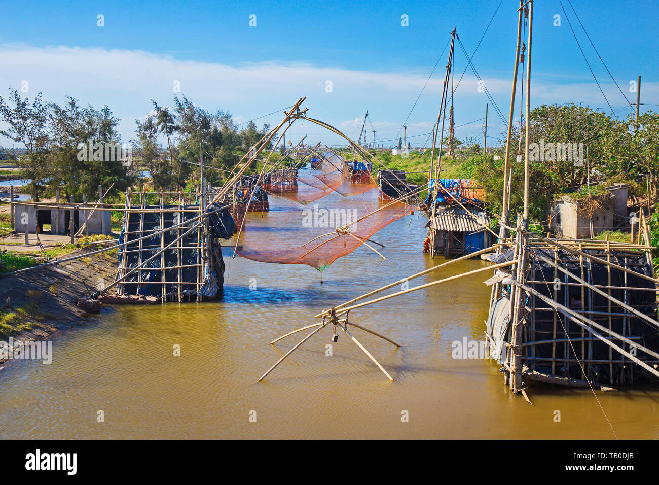 A traditional fishing net with bamboo frames on the river at sunset ...