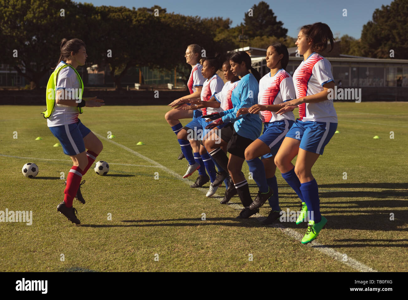 Team of female soccer players warming up at sports field Stock Photo ...