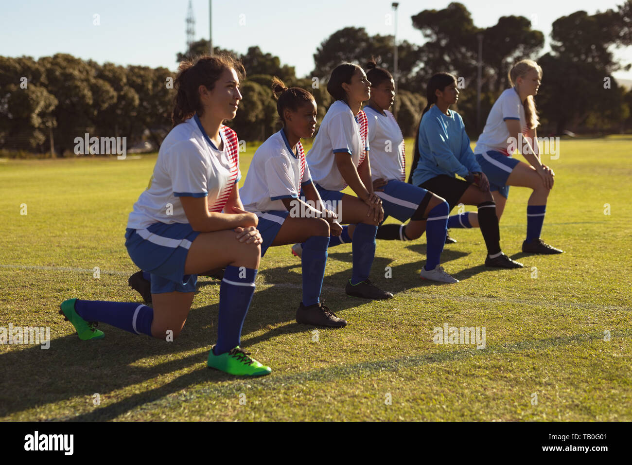 Female soccer players doing warm-up exercise on the field Stock Photo ...
