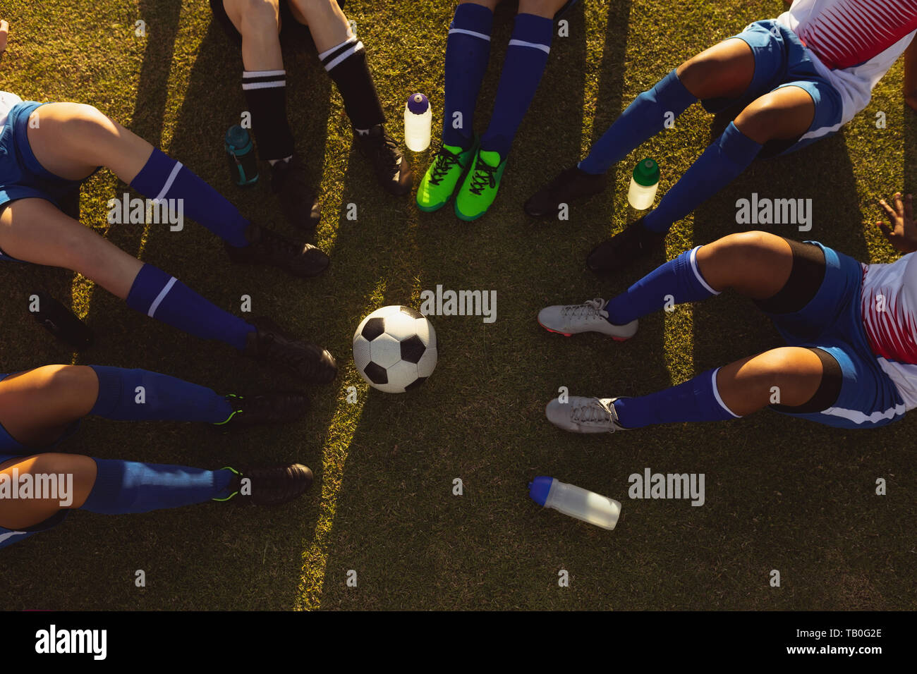 Players sitting in a circle with ball in between Stock Photo - Alamy