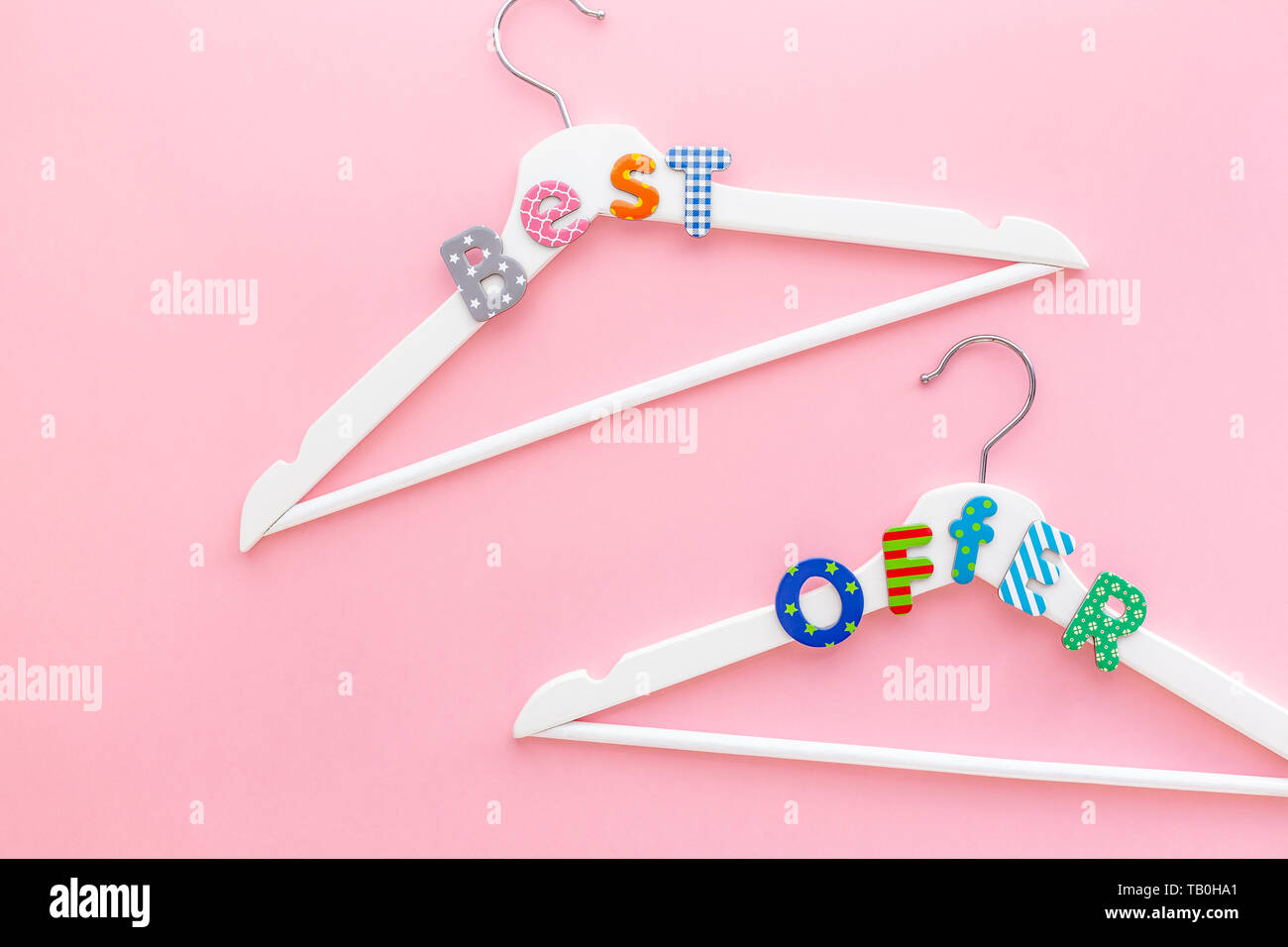 Creative top view flat lay white wooden hangers best offer pastel pink ...