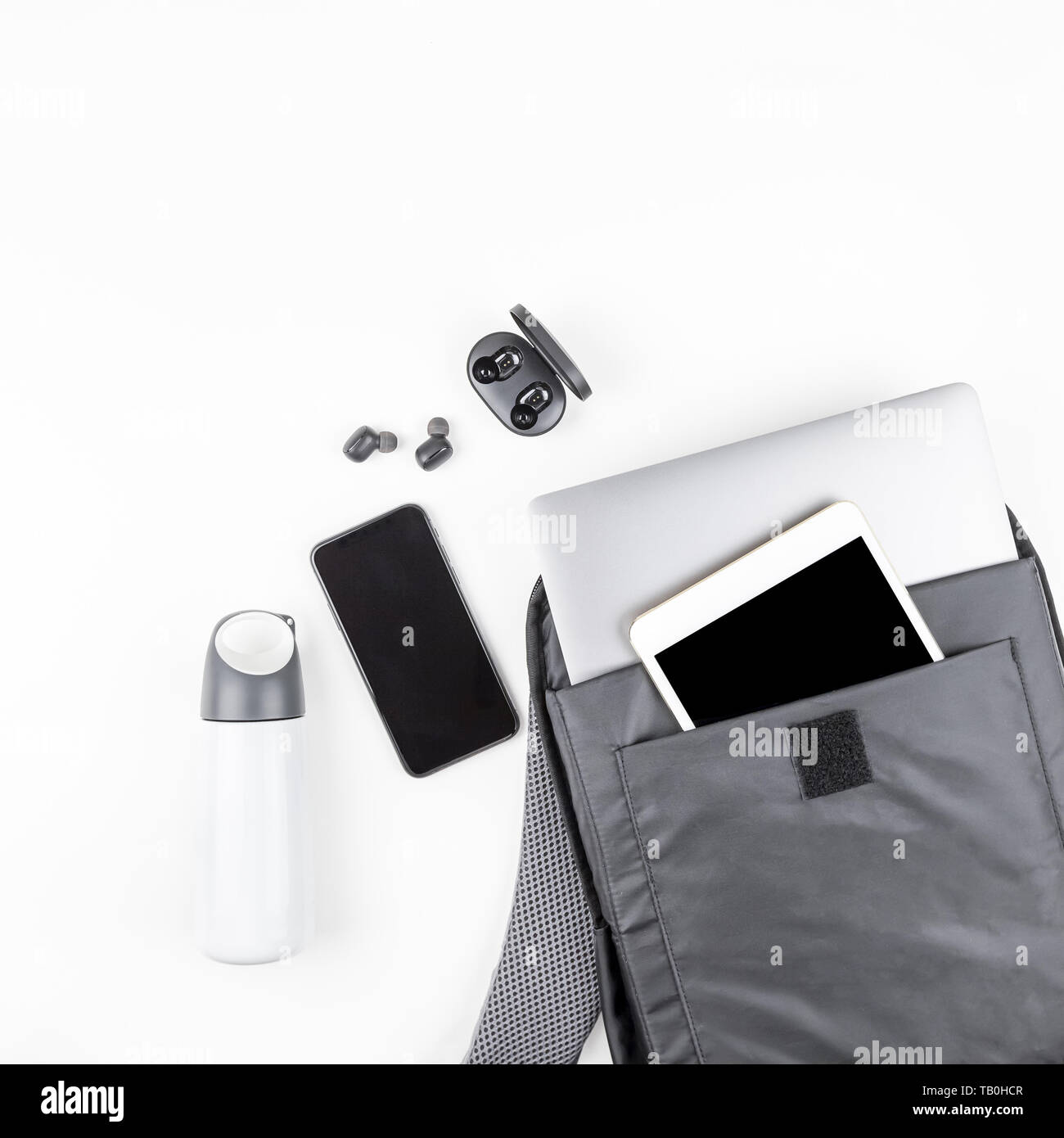 Creative top view flat lay of open backpack with laptop and tablet ...