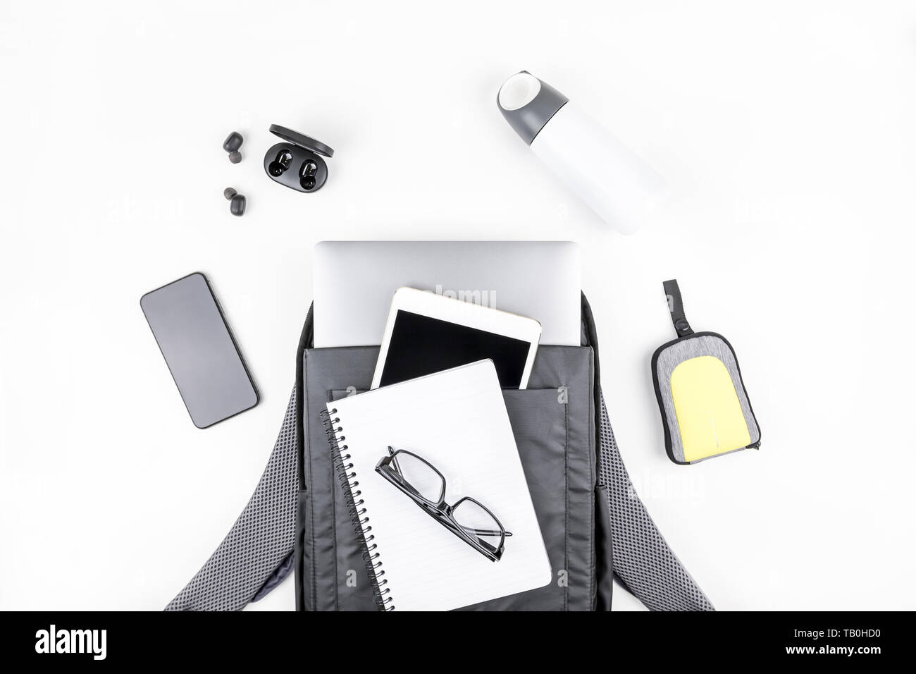 Creative top view flat lay of open backpack with laptop and tablet ...