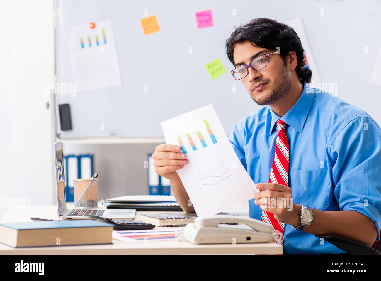 Young male financial manager working in the office Stock Photo - Alamy
