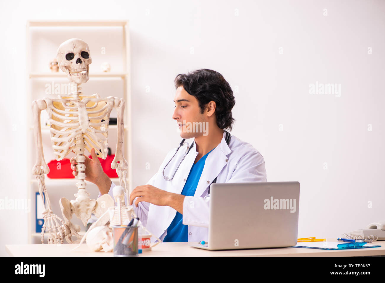 Young male doctor with skeleton Stock Photo - Alamy