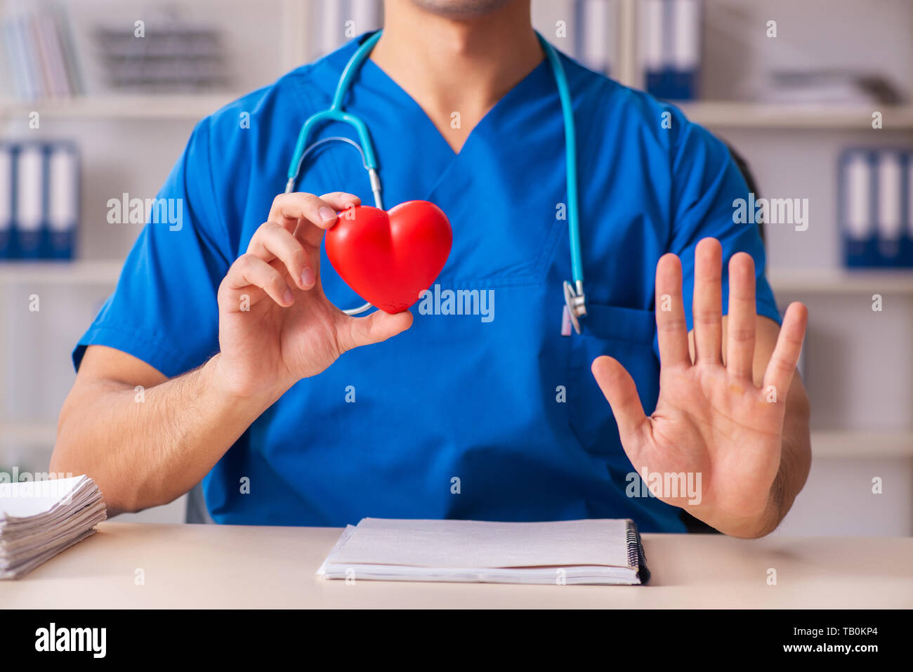 Male doctor cardiologist holding heart model Stock Photo - Alamy