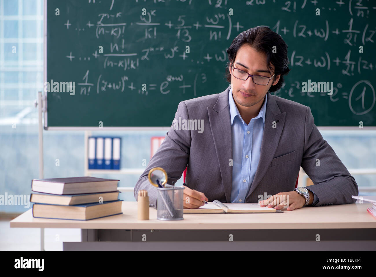 Young handsome math teacher in classroom Stock Photo - Alamy