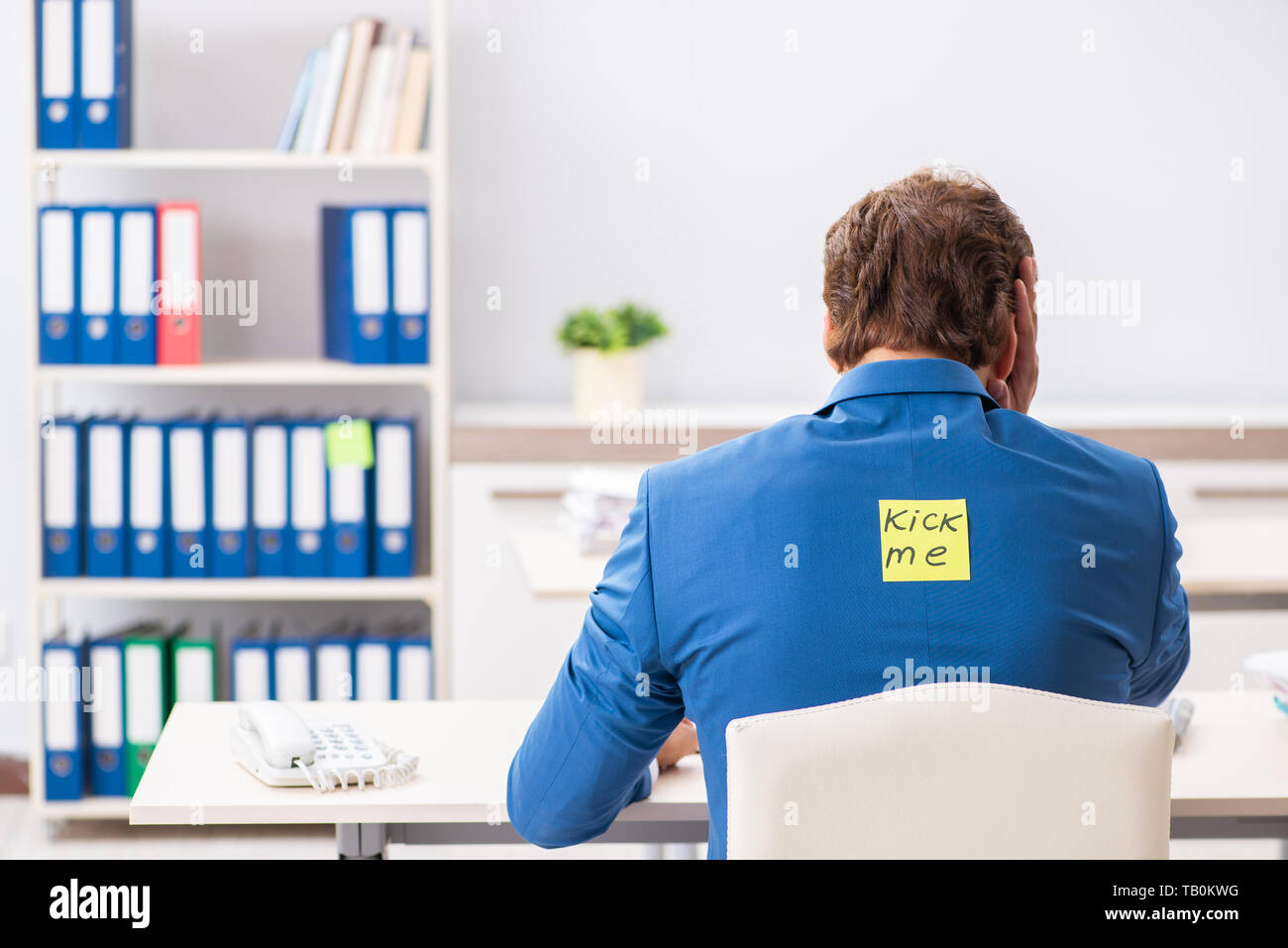 Office prank with kick me message on sticky note Stock Photo - Alamy