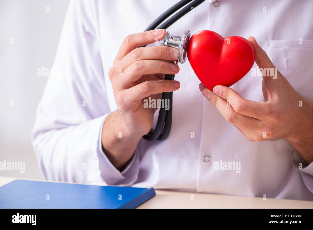 Male doctor cardiologist holding heart model Stock Photo - Alamy