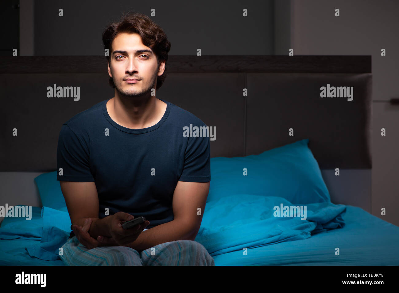 Man watching tv at night in bed Stock Photo - Alamy