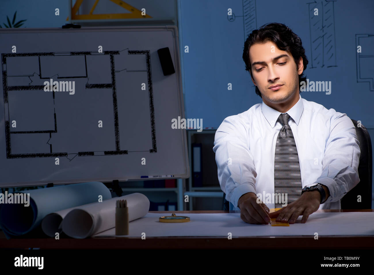 Young construction architect working on project at night Stock Photo ...