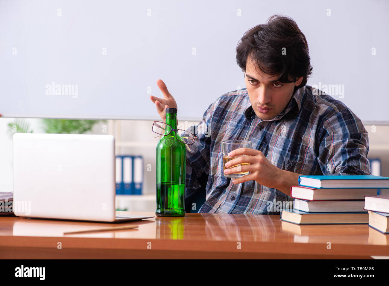 Male teacher drinking in the classroom Stock Photo - Alamy