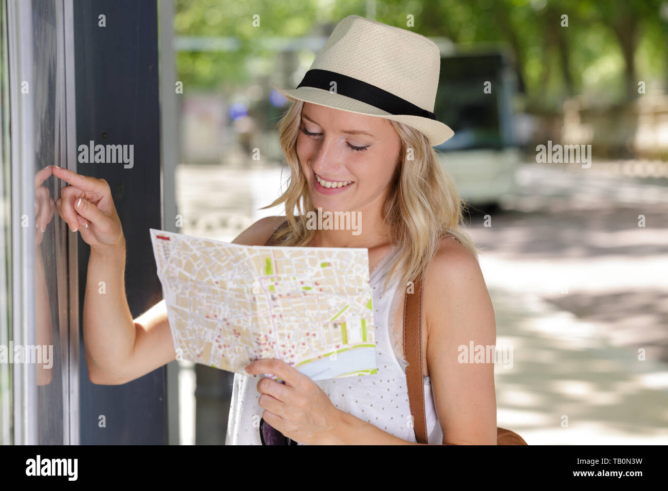 beautiful female tourist searching a place on the map Stock Photo - Alamy