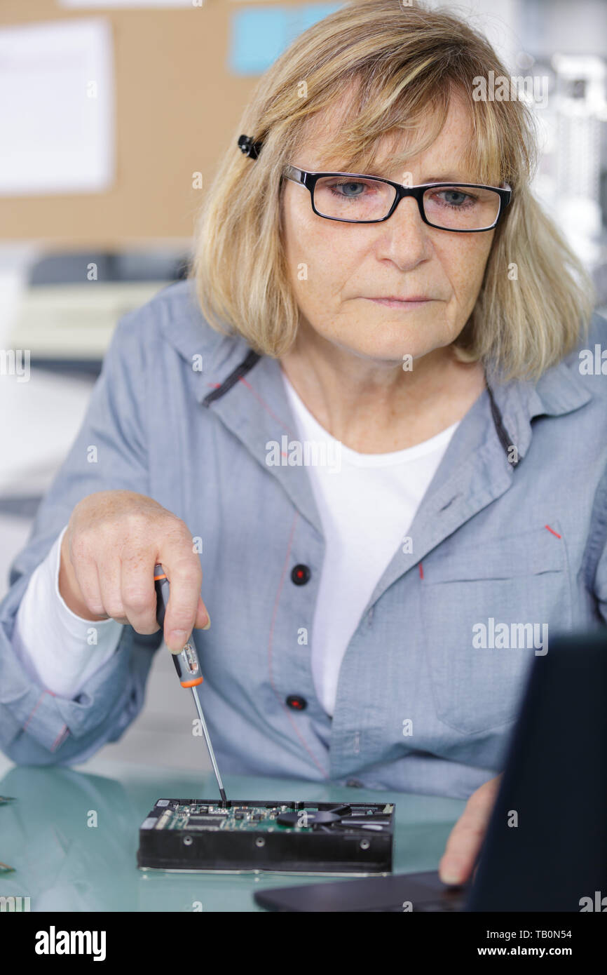 female unscrewing a back of a laptop Stock Photo - Alamy