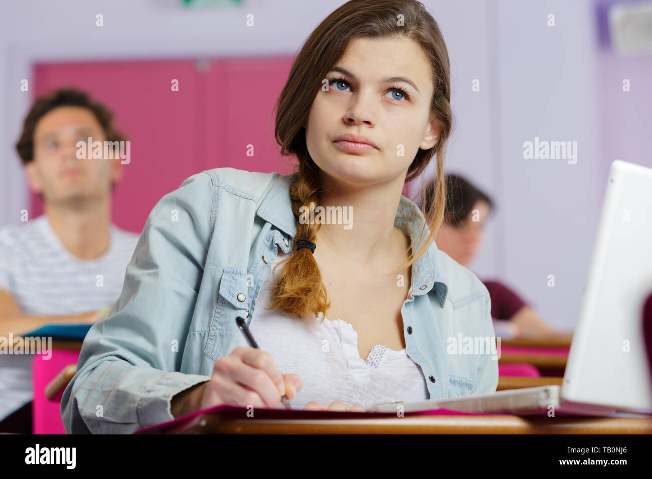 female student making notes while listening to lecture Stock Photo - Alamy