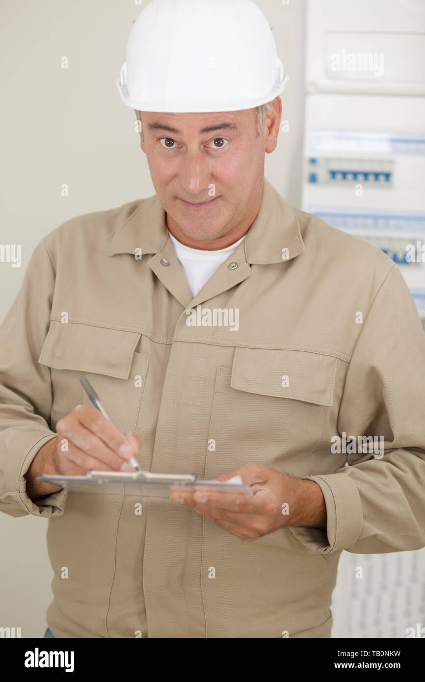 engineer man wearing a helmet and holding his clipboard Stock Photo - Alamy