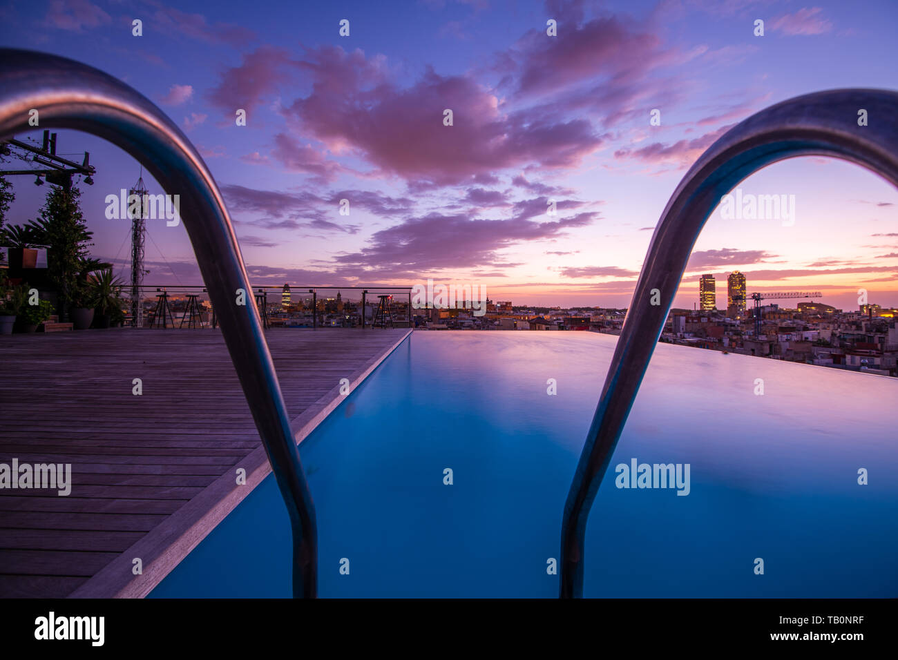 Luxury roof top swimming pool with infinity edge, early morning sunrise ...