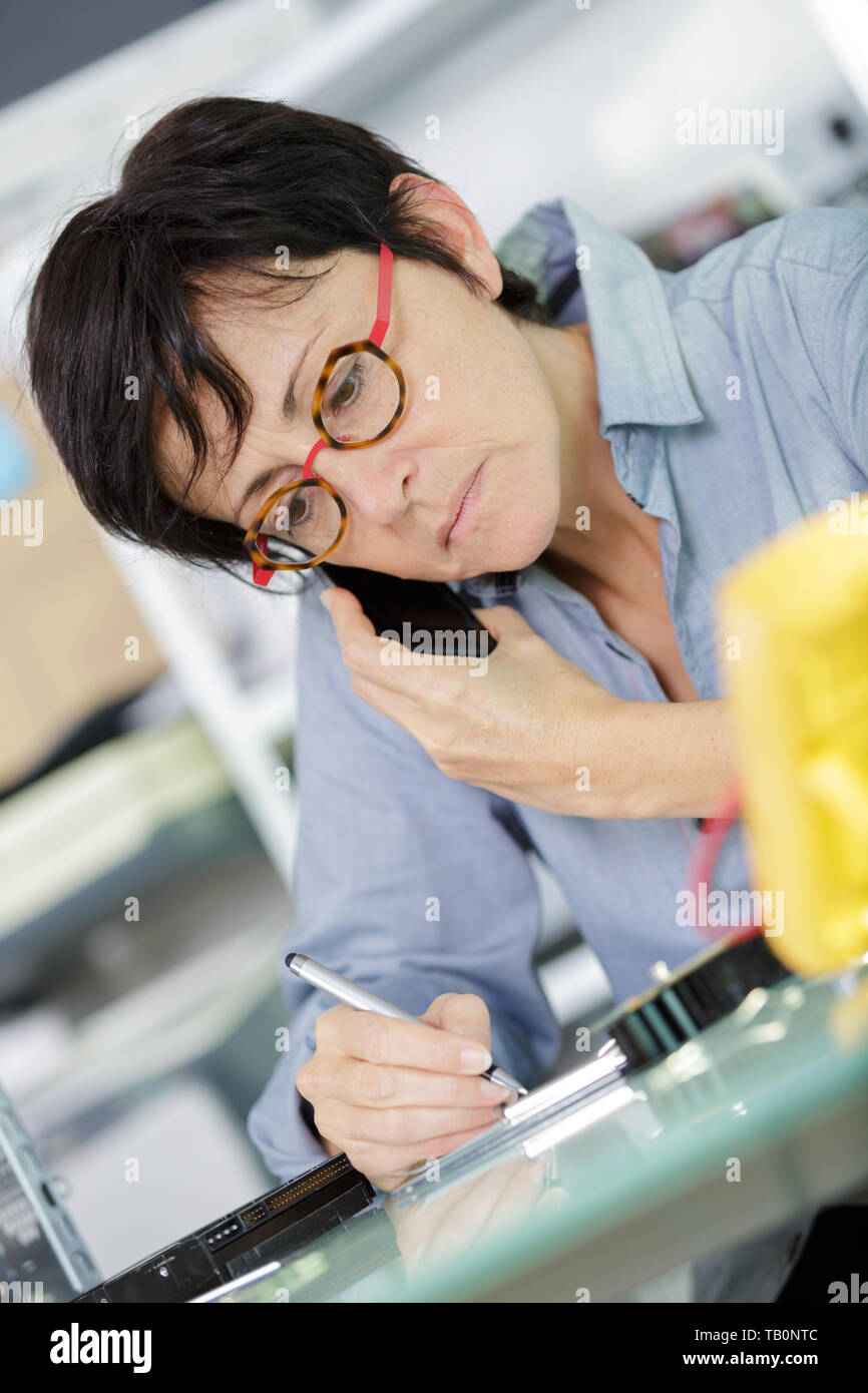 woman talking to a customer about an invoice Stock Photo - Alamy