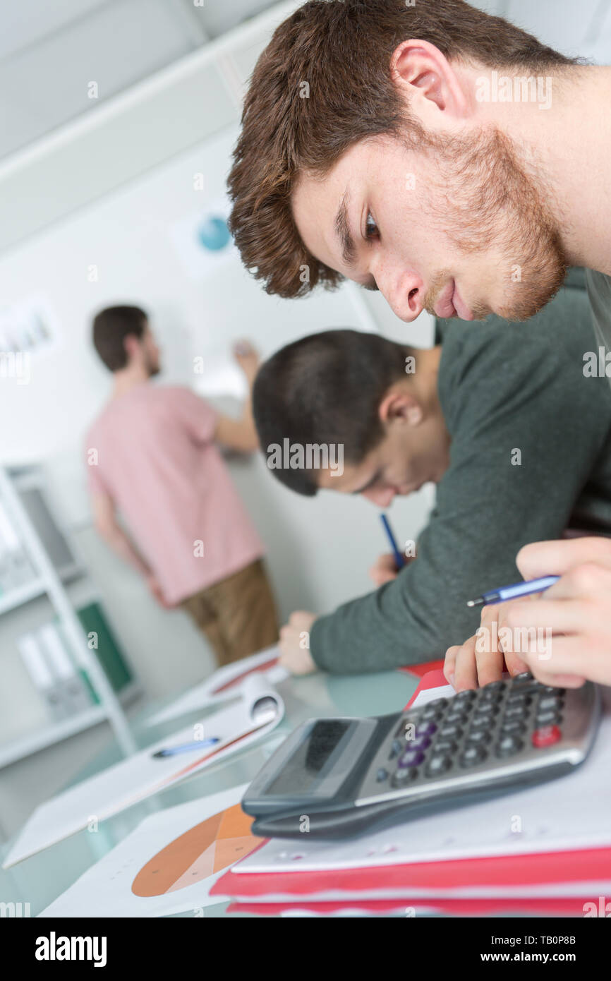 teenage male student using calculator in class Stock Photo - Alamy