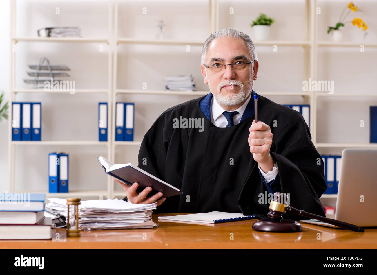Aged lawyer working in the courthouse Stock Photo - Alamy
