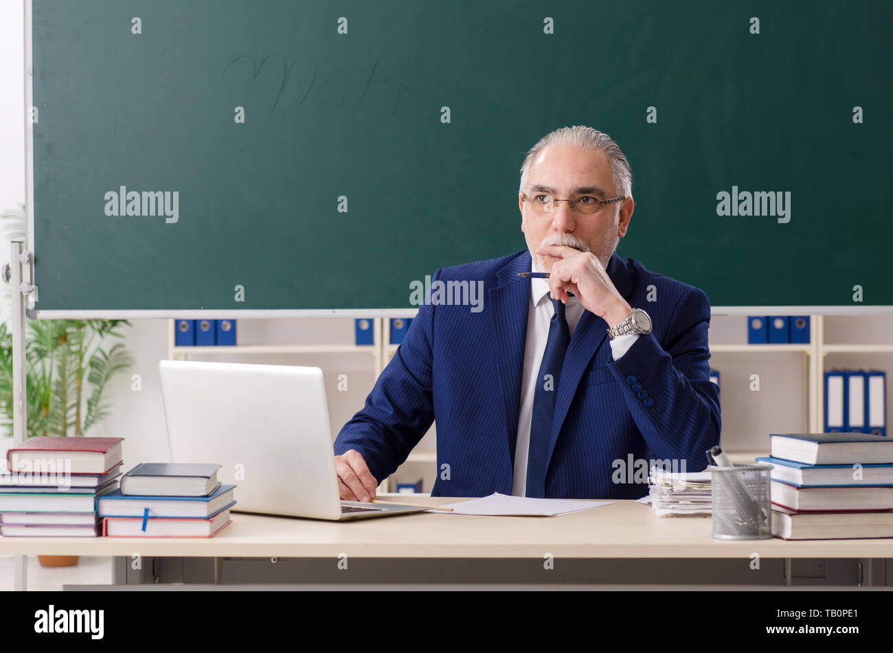 Aged male teacher in front of chalkboard Stock Photo - Alamy