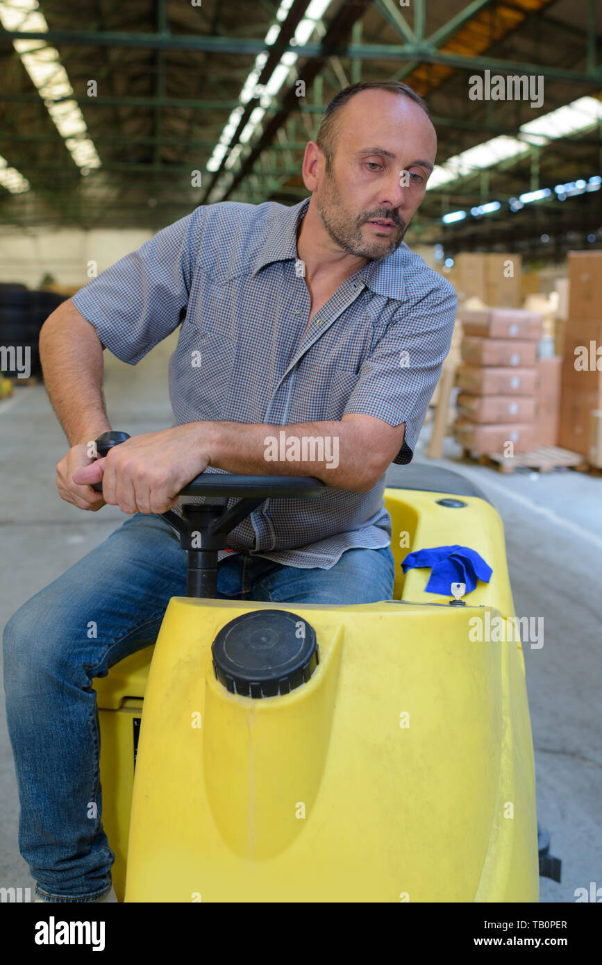 man driving a vehicle in a warehouse Stock Photo - Alamy