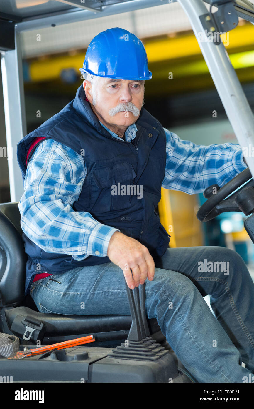 senior man or loader operating forklift loader at warehouse Stock Photo ...