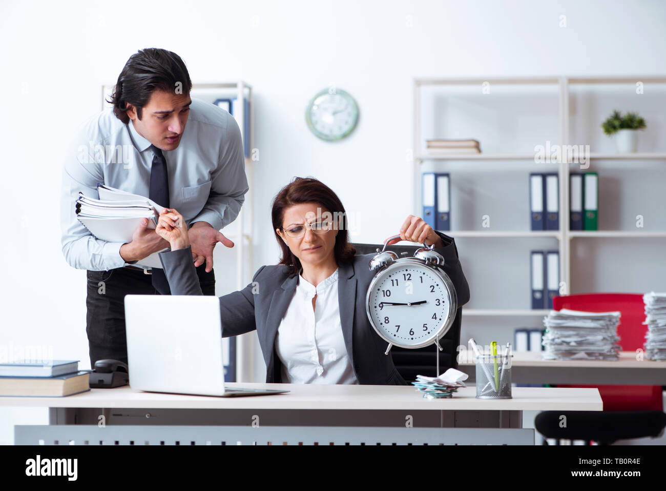 Old female boss and young male employee in the office Stock Photo - Alamy