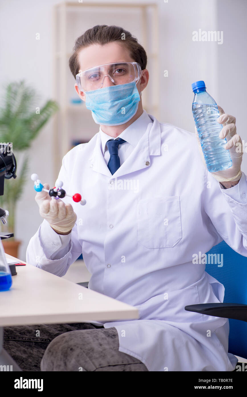 The young male chemist experimenting in lab Stock Photo - Alamy
