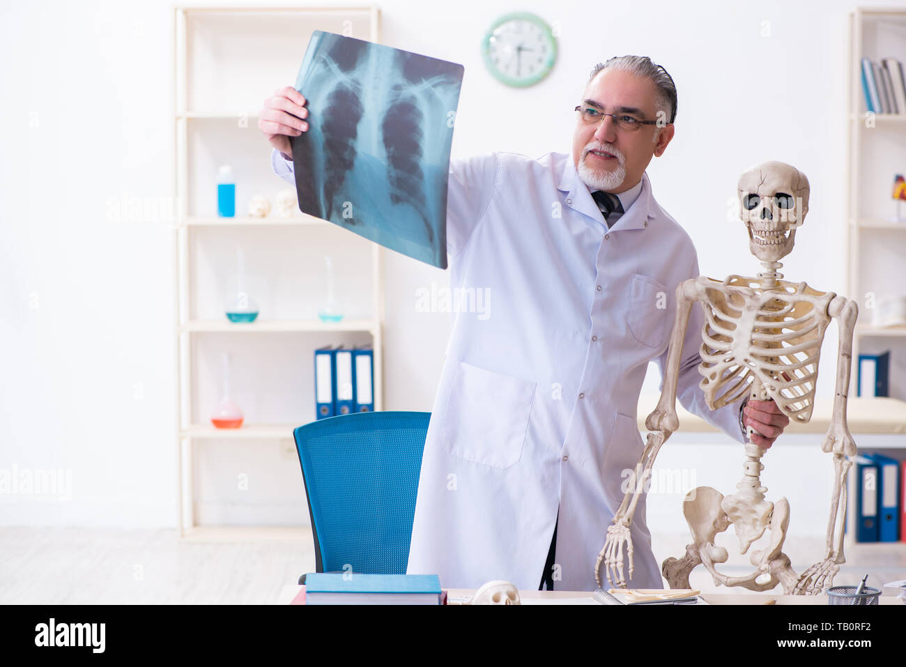 The aged male doctor with skeleton Stock Photo - Alamy