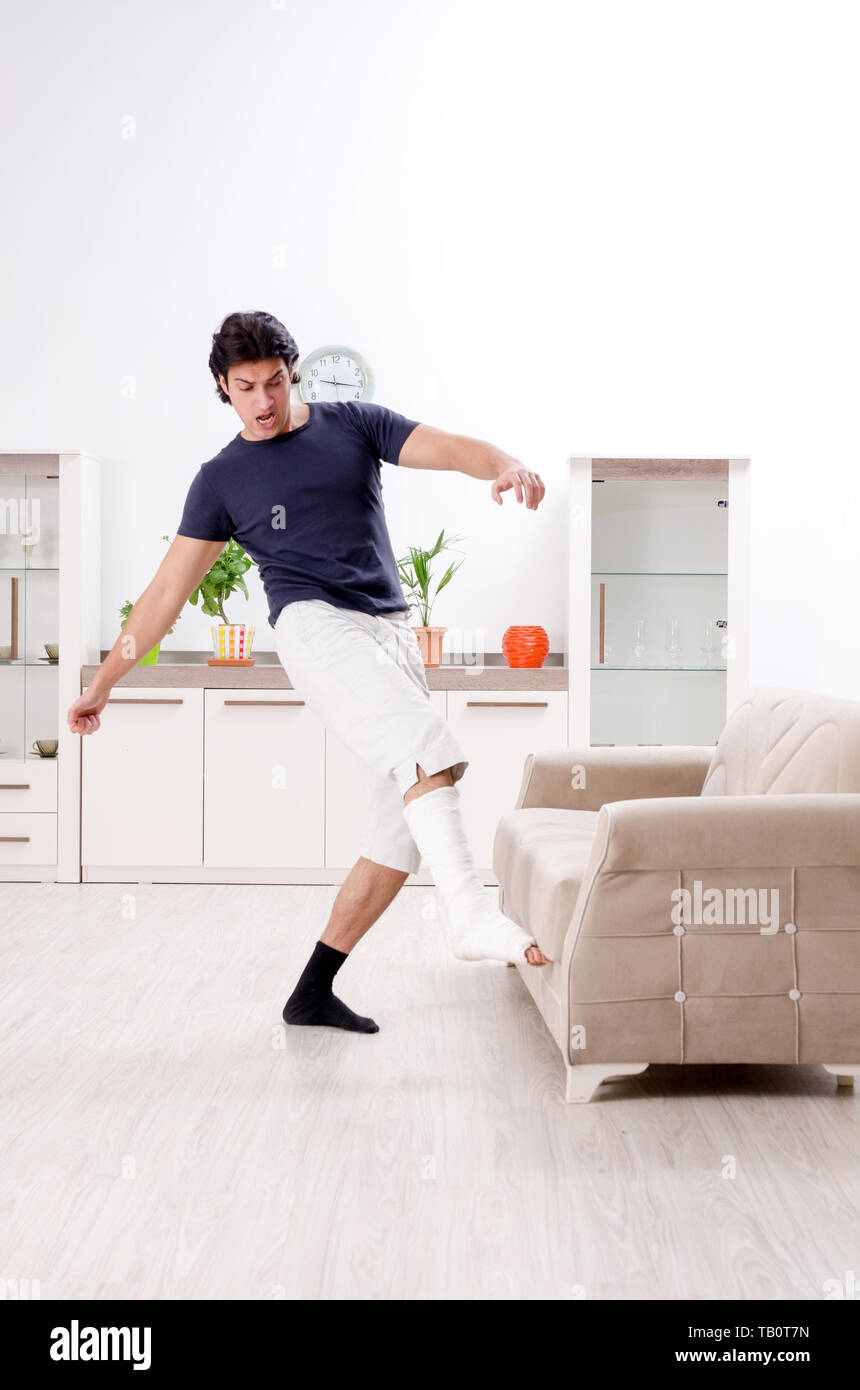 Leg injured young man suffering at home Stock Photo - Alamy