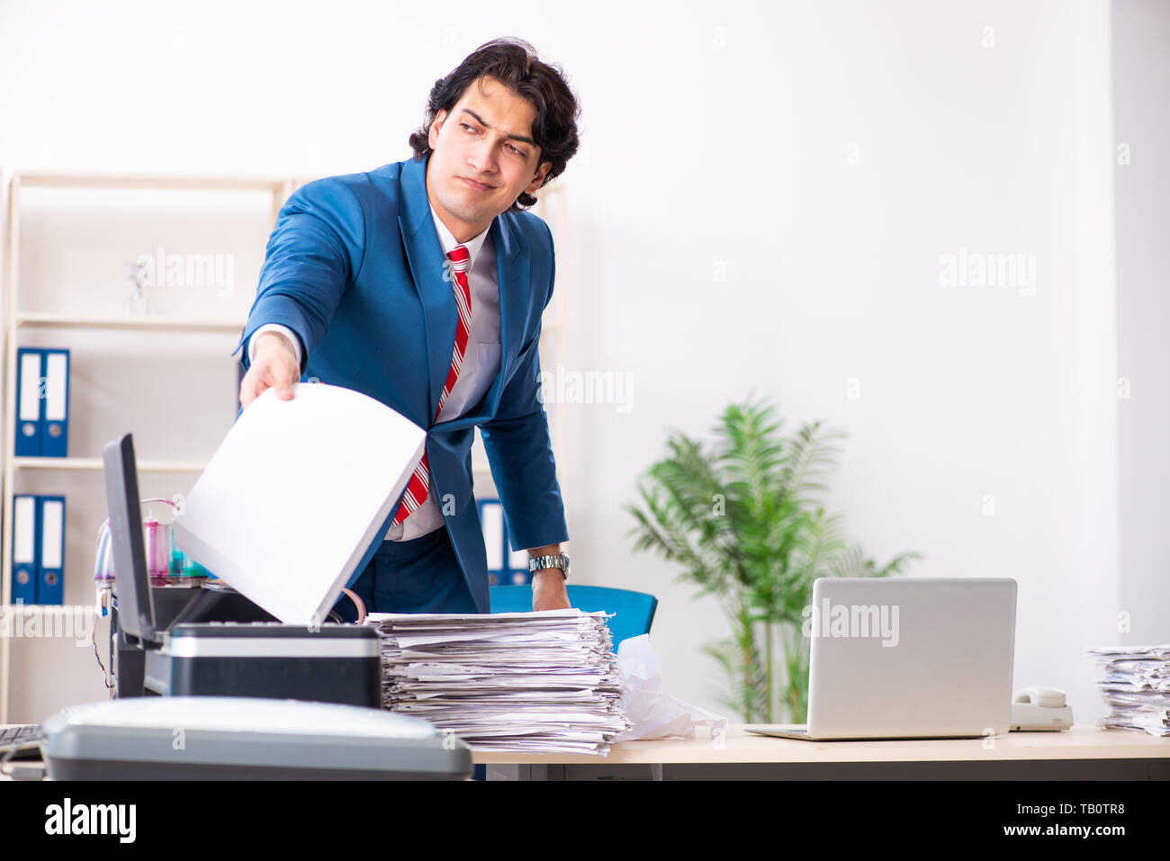 Young employee making copies at copying machine Stock Photo - Alamy