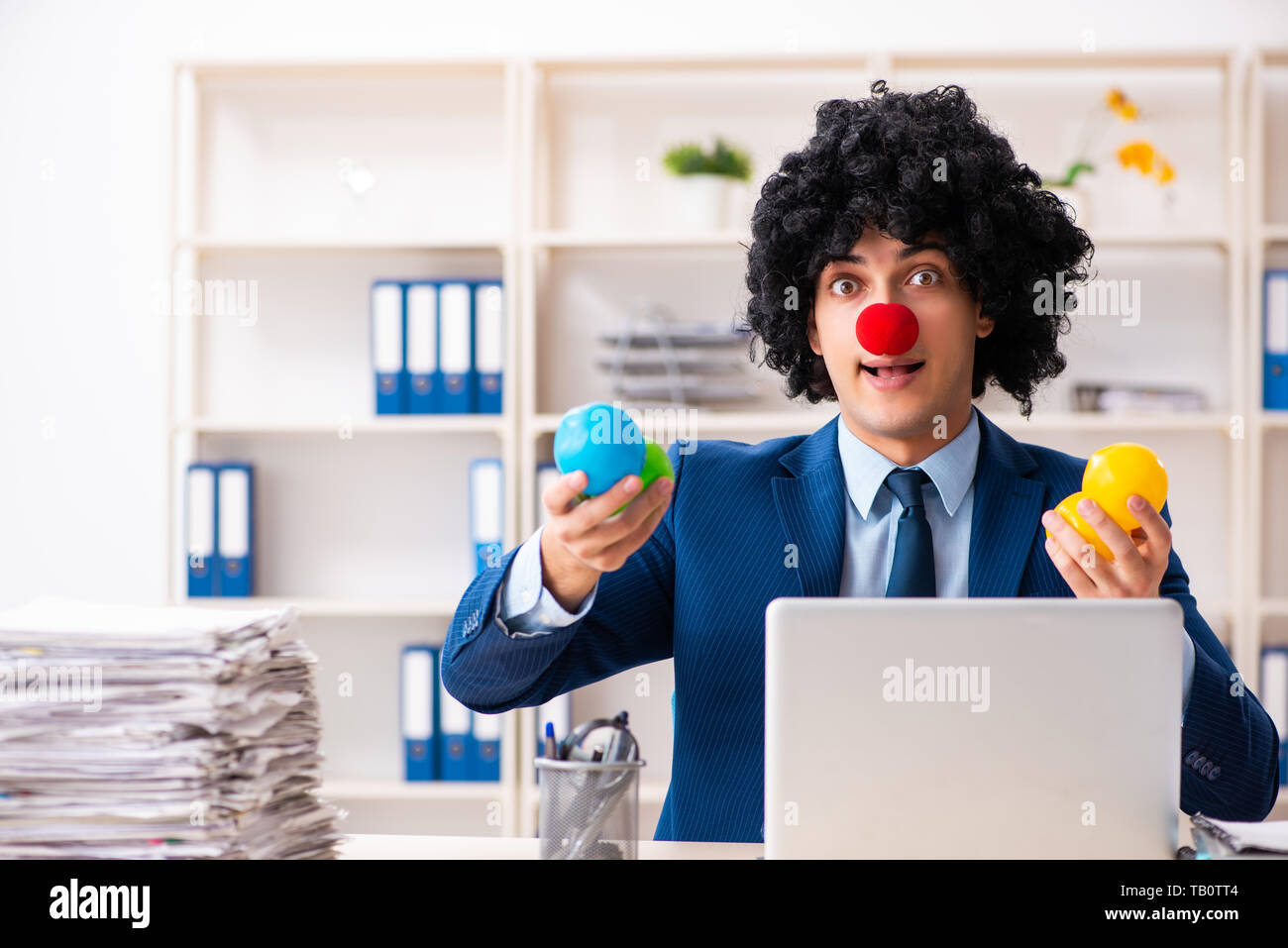 Young clown businessman working in the office Stock Photo - Alamy