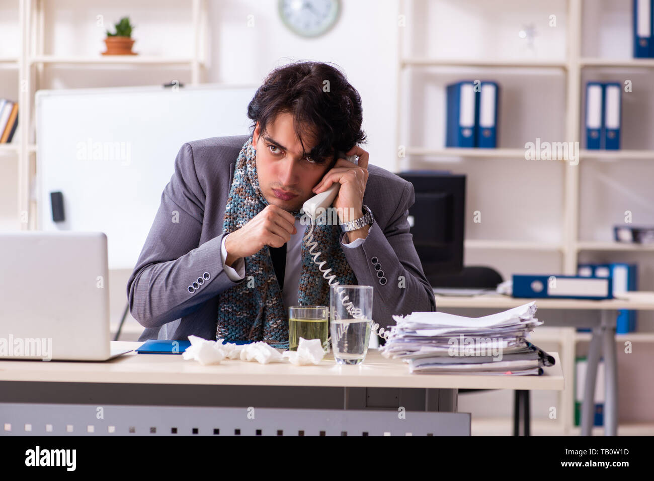 Young male employee suffering at workplace Stock Photo - Alamy