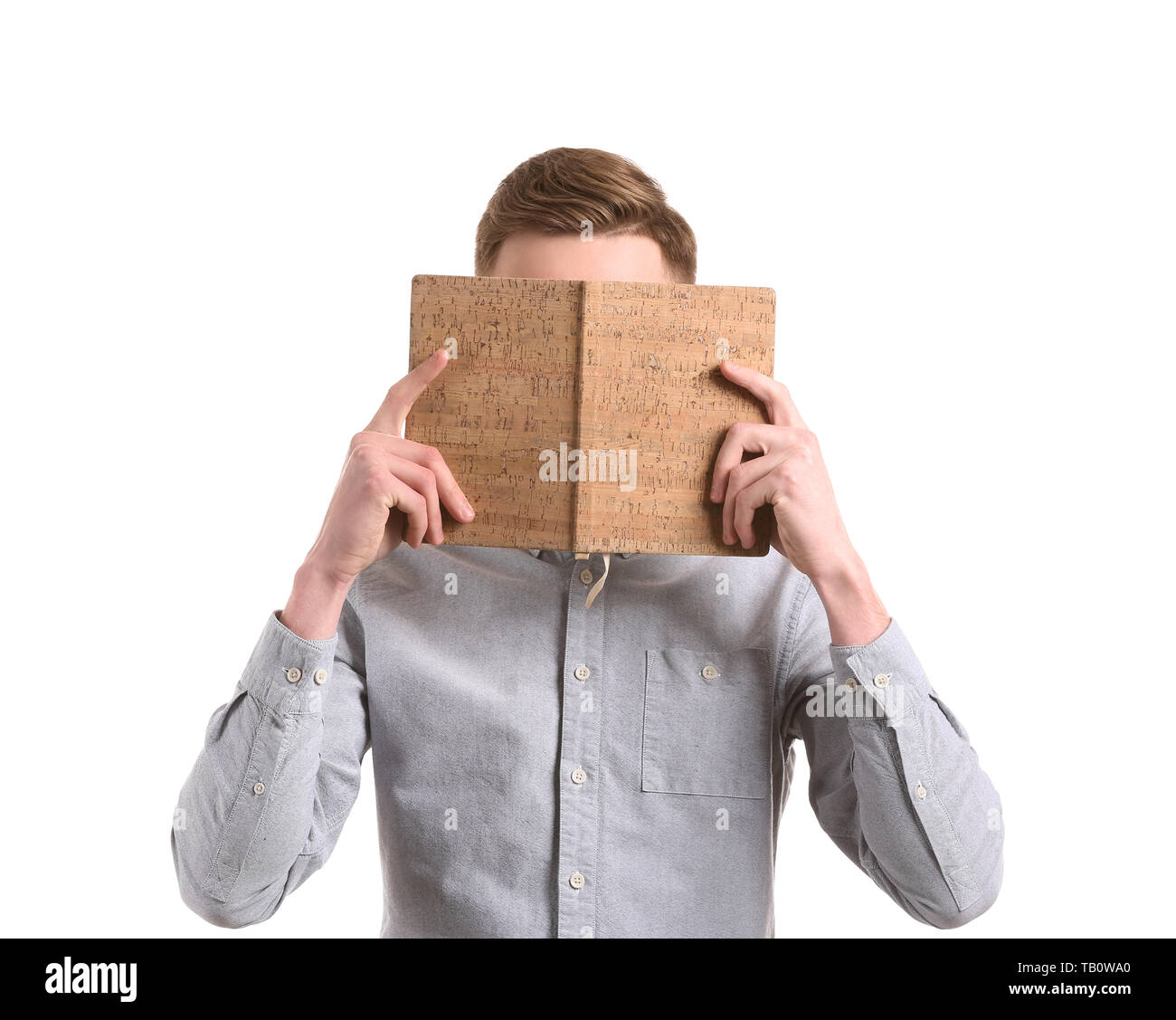 Young man with book covering his face hi-res stock photography and ...