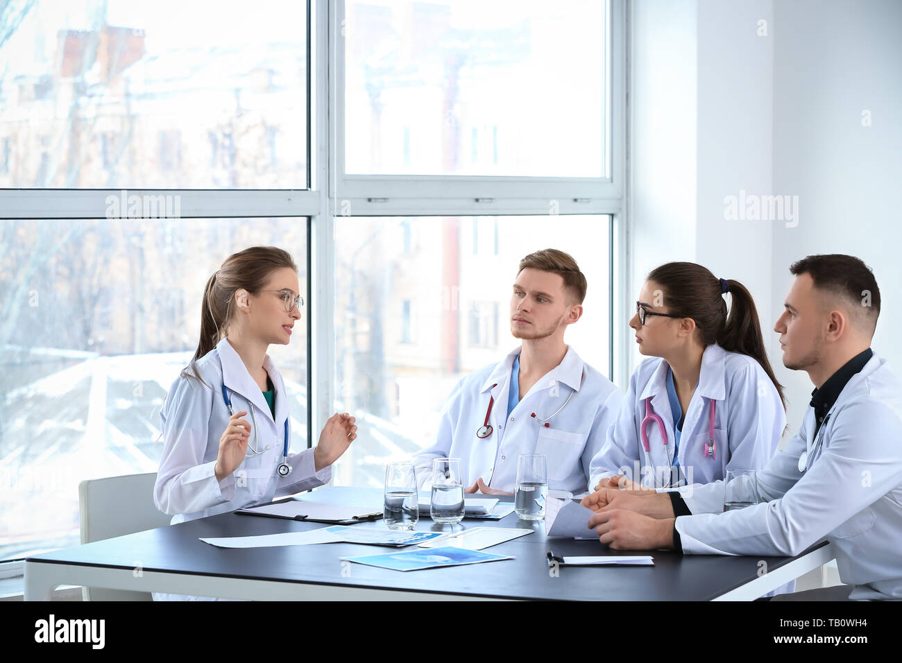 Medical team sitting discussing table hi-res stock photography and ...