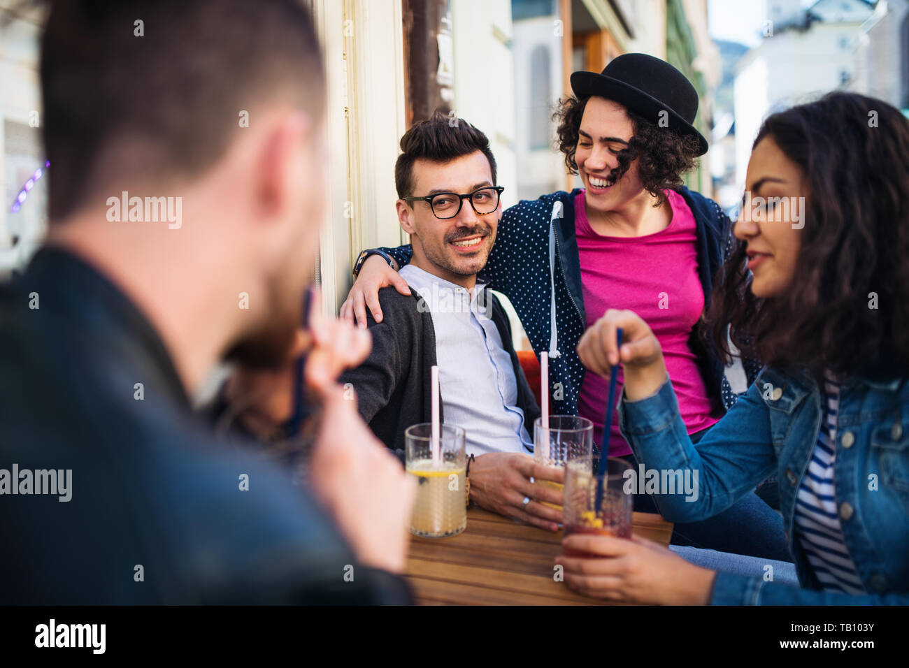 A group of young friends sitting in an outdoor cafe, talking Stock ...