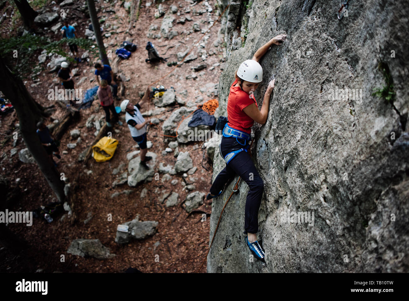 Girl climbing outside with white helmet Stock Photo - Alamy