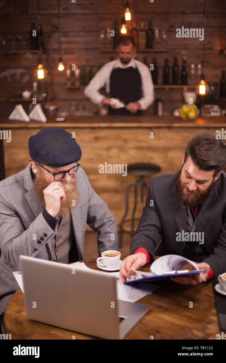 Thoughtfull businessmen working in a coffee shop. Successful men ...