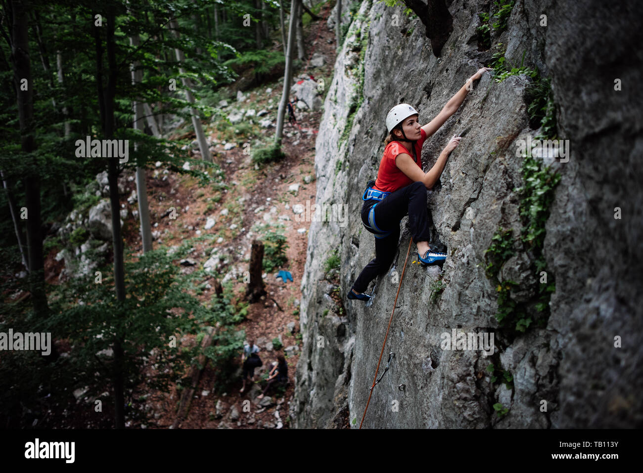 Girl climbing outside with white helmet Stock Photo - Alamy